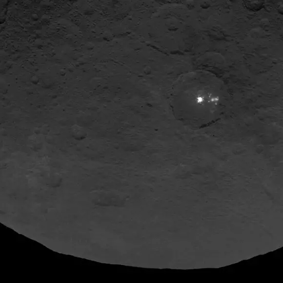 Þyrping af dularfullum björtum blettum á dvergreikistjörnunni Ceres má sjá á þessari mynd, tekin af Dawn geimfari NASA úr 2.700 mílna hæð (4.400 kílómetra). Myndin var tekin 9. júní 2015.