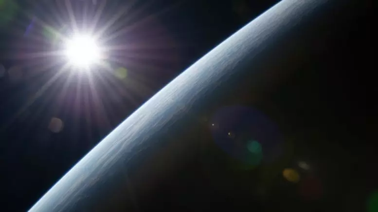 Promienie słoneczne rozbłyskują nad horyzontem Ziemi