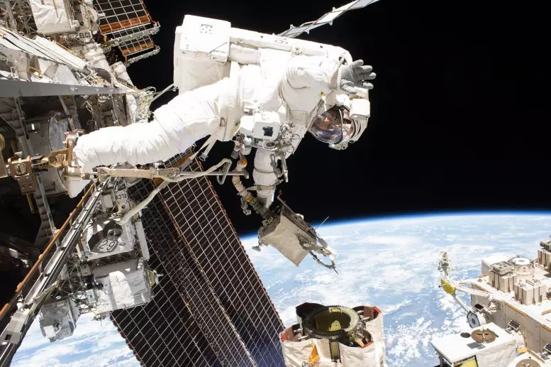 O caminhante espacial Mark Vande Hei trabalha no braço robótico Canadarm2